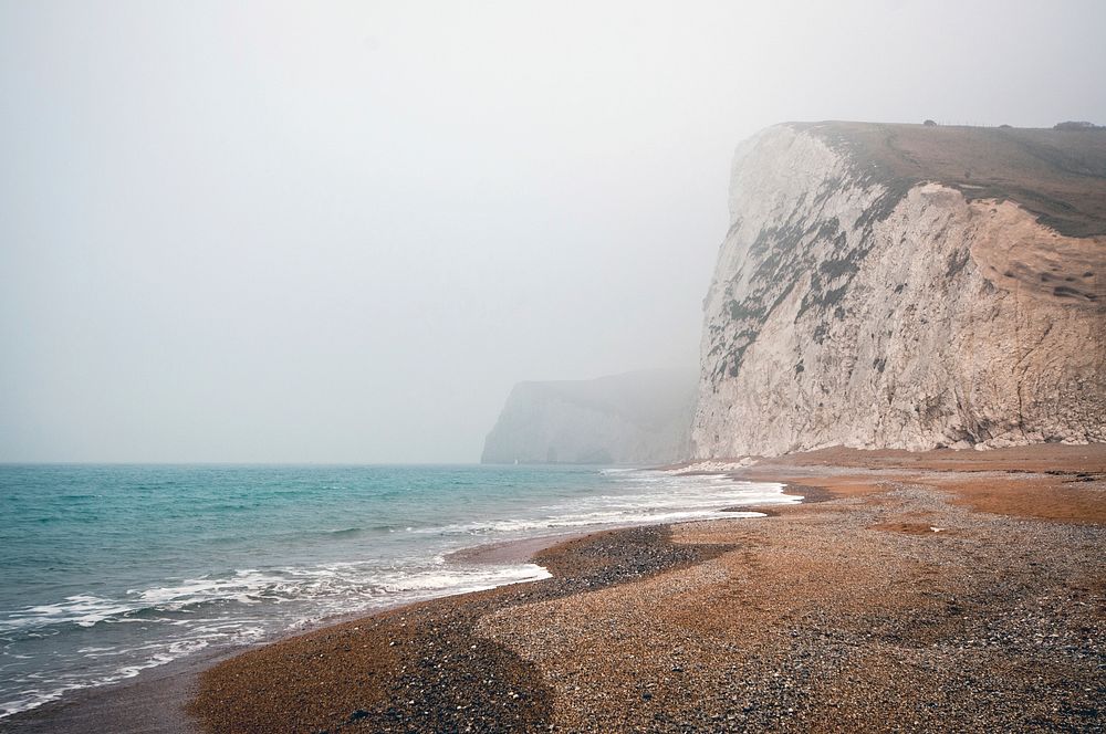 Bluffs line the seashore of a foggy | Free Photo - rawpixel