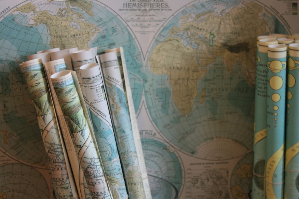 Rolled maps standing against a world | Free Photo - rawpixel