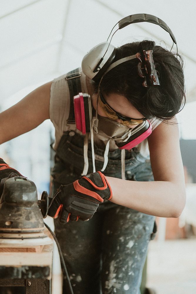 Female carpenter smoothing the lumber | Photo - rawpixel