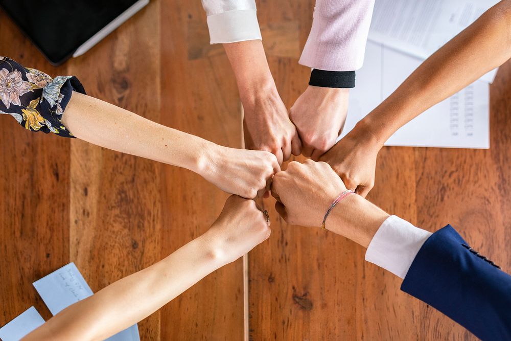 Team making a group fist | Photo - rawpixel