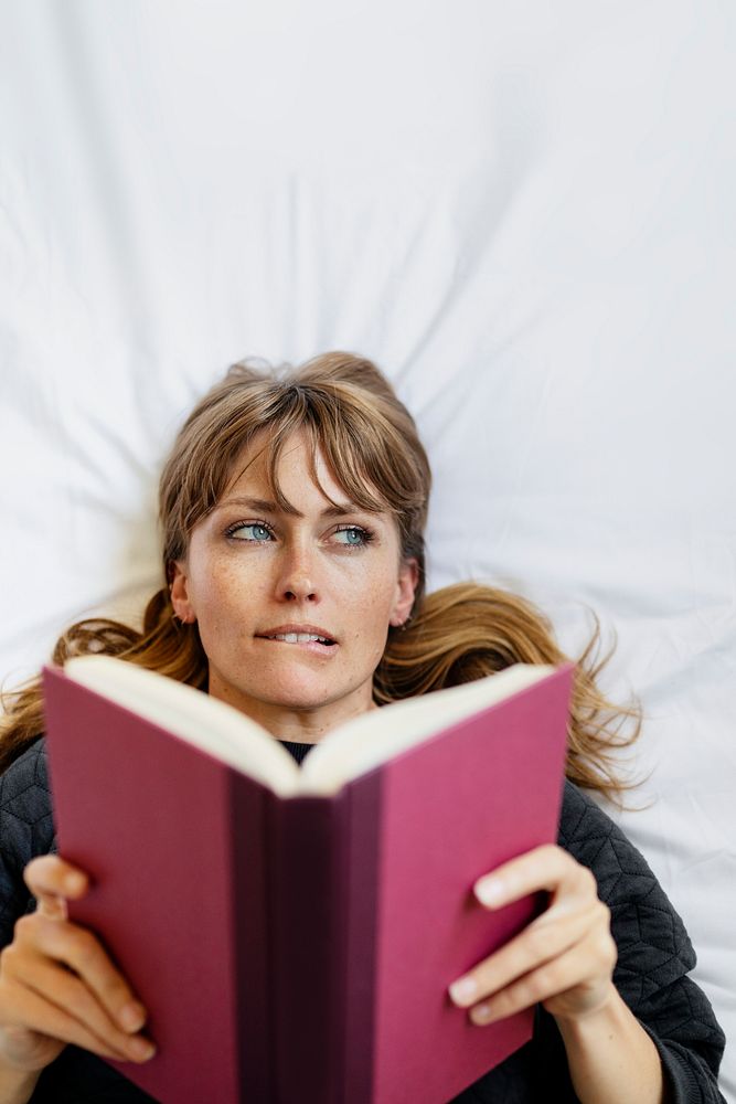 Woman reading a book on a bed | Free Photo - rawpixel