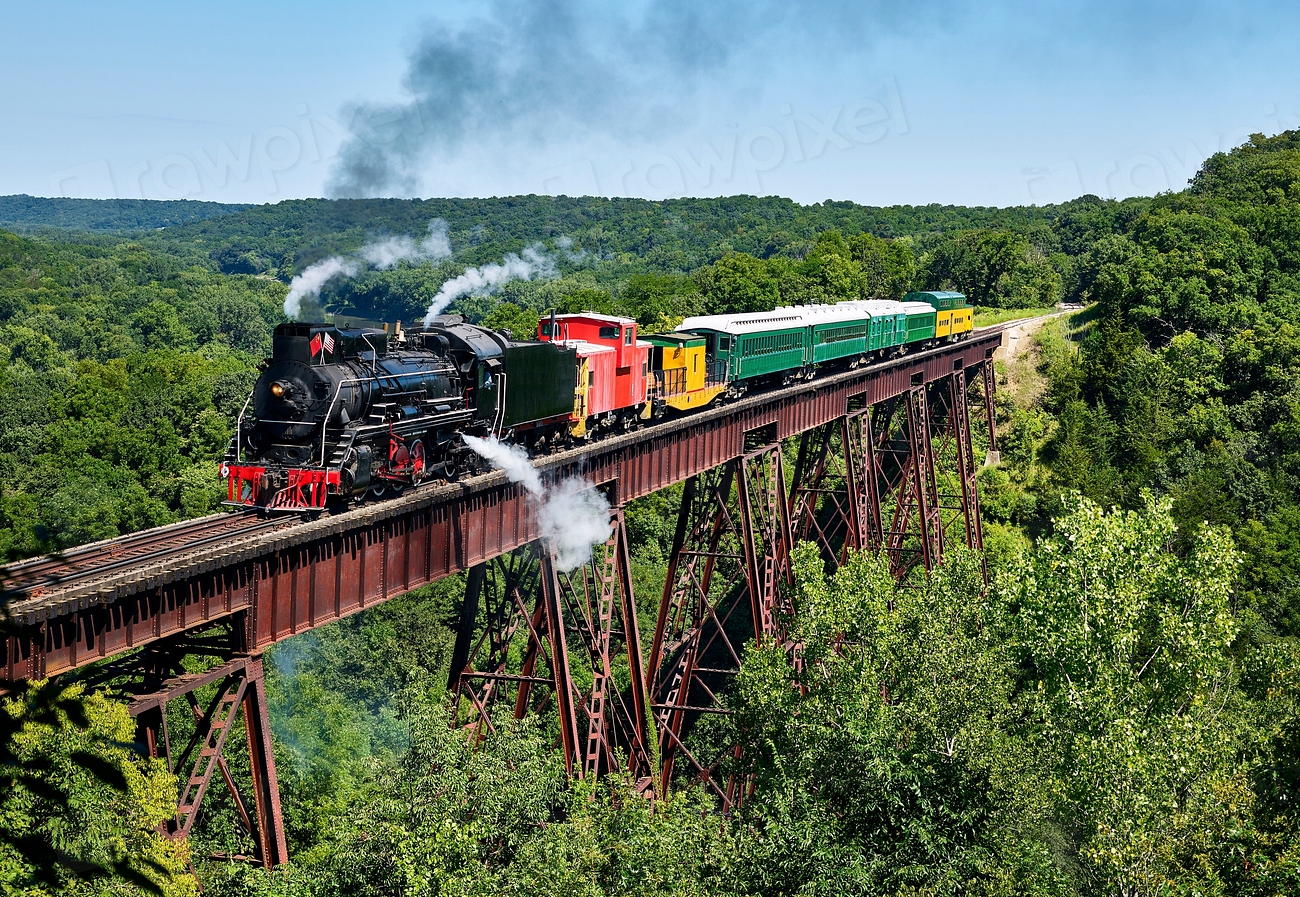 A steam train crosses the 156-foot-tall | Free Photo - rawpixel