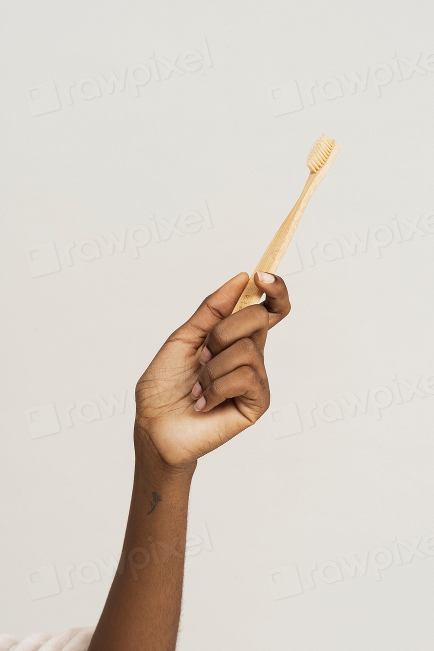 Hand showing a bamboo toothbrush | Premium Photo - rawpixel