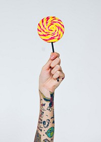 Tattooed hand showing a lollipop | Free Photo - rawpixel