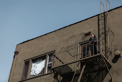 Woman standing on fire escape | Free Photo - rawpixel