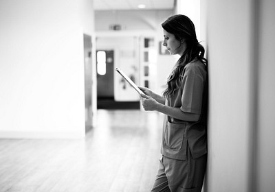 Nurse reading through medical records | Photo - rawpixel