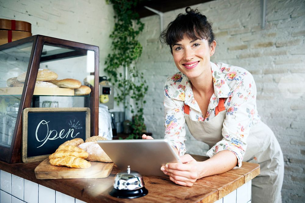 Friendly bakery owner using tablet | Free Photo - rawpixel