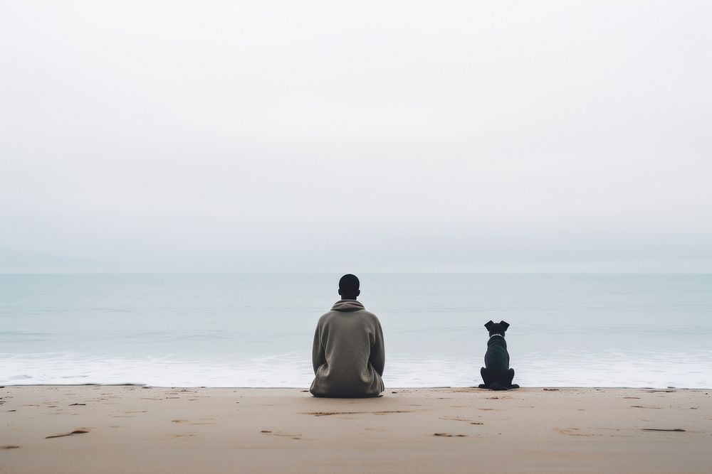 Man and dog sitting beach | Premium Photo - rawpixel