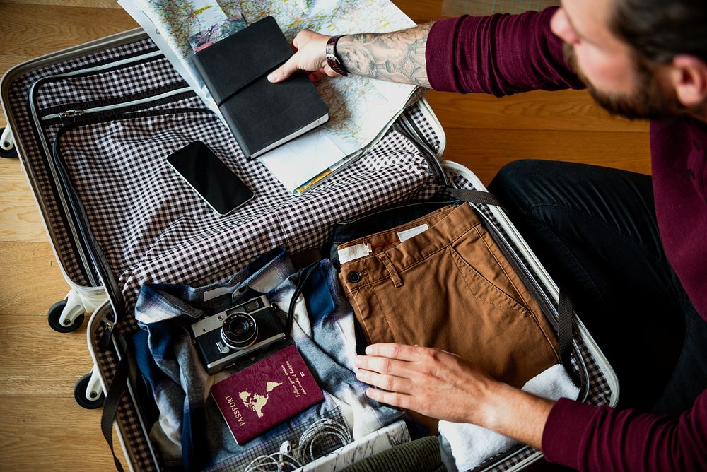 Man packing suitcase clothes, map, | Free Photo - rawpixel