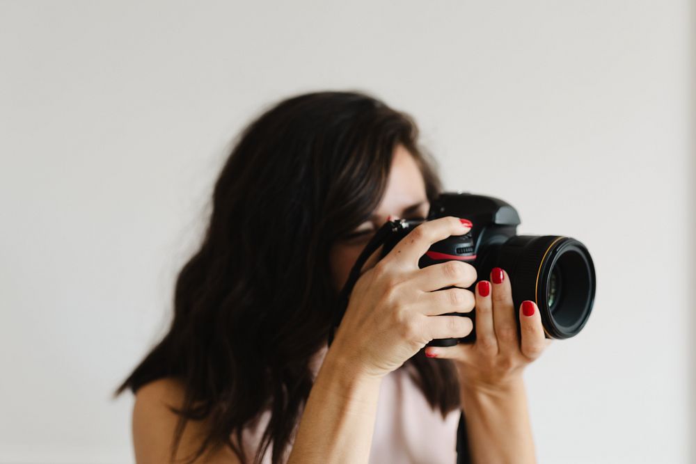 Content creator holding camera, focusing | Free Photo - rawpixel