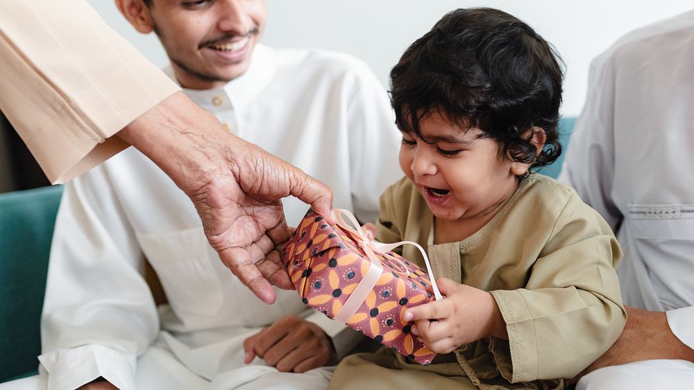 Child receiving gift, smiling joy. | Free Photo - rawpixel