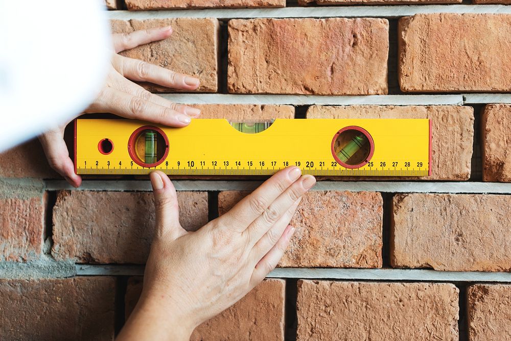 Hands using yellow level tool | Free Photo - rawpixel