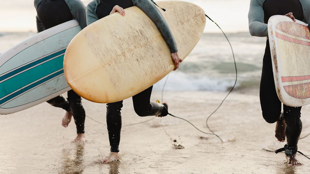 Three surfers carrying surfboards run | Free Photo - rawpixel