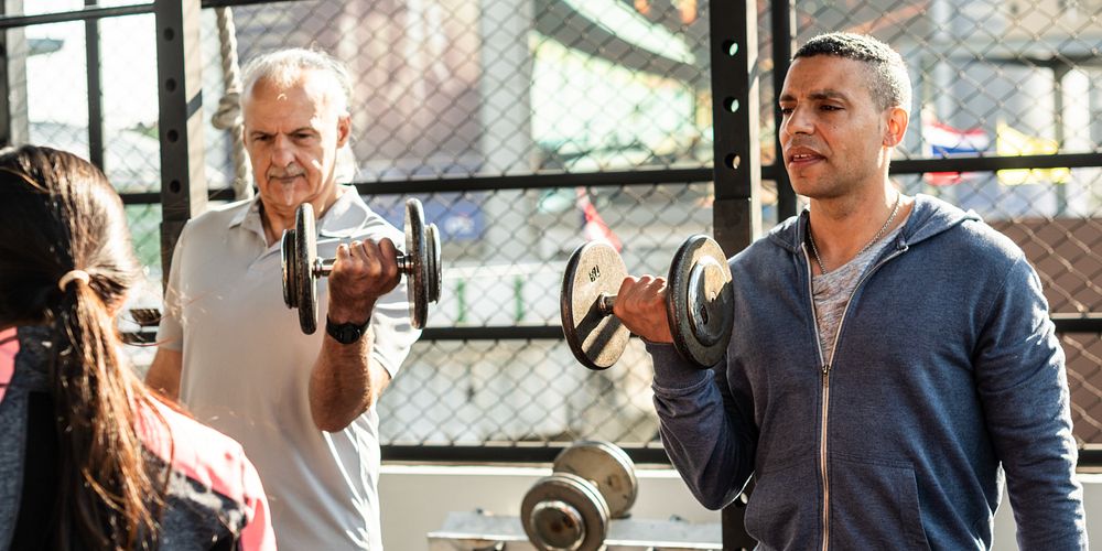 Two men lifting dumbbells gym. | Free Photo - rawpixel