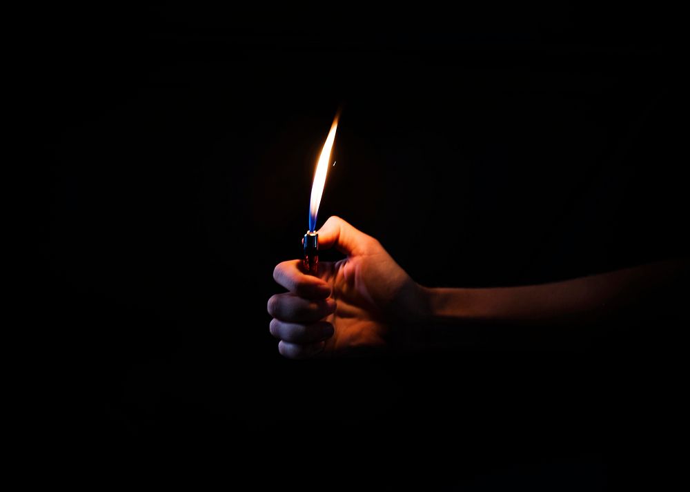 Hand holding lit lighter dark | Premium Photo - rawpixel
