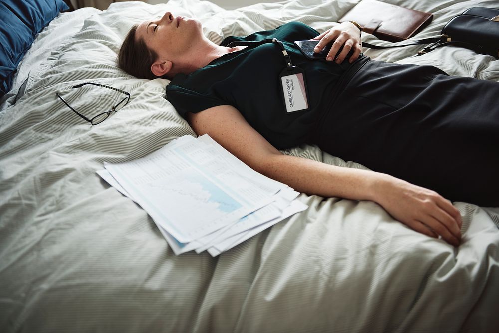 A woman passing out in bed | Photo - rawpixel