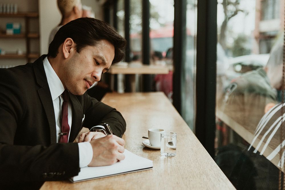 Businessman writing in a cafe | Premium Photo - rawpixel