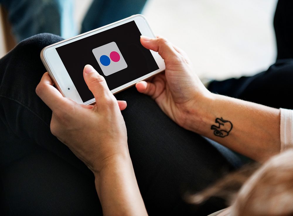 Woman using Flickr application phone. | Free Photo - rawpixel