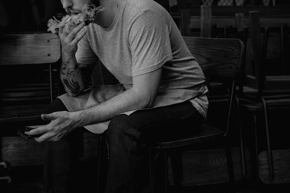 Man sitting and smoking on the chair | Photo - rawpixel
