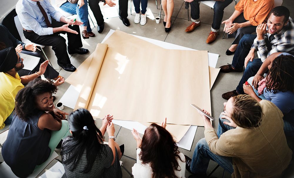 Seated people surrounding sheet paper | Premium Photo - rawpixel