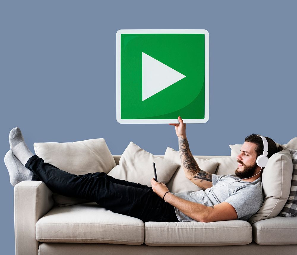 Male couch holding play button | Premium Photo - rawpixel