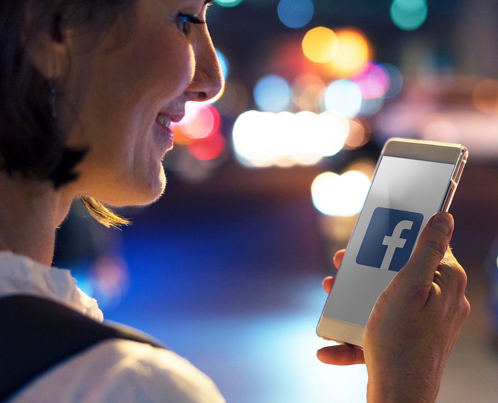 Woman using Facebook on a phone | Free Photo - rawpixel