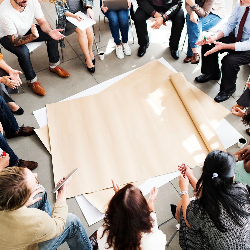 Seated people surrounding sheet paper | Premium Photo - rawpixel